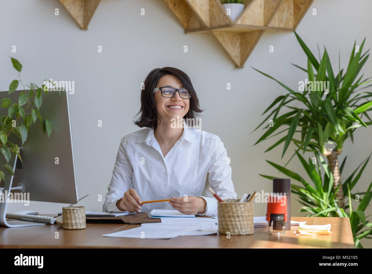 Woman smiling at office during working day Stock Photo - Alamy