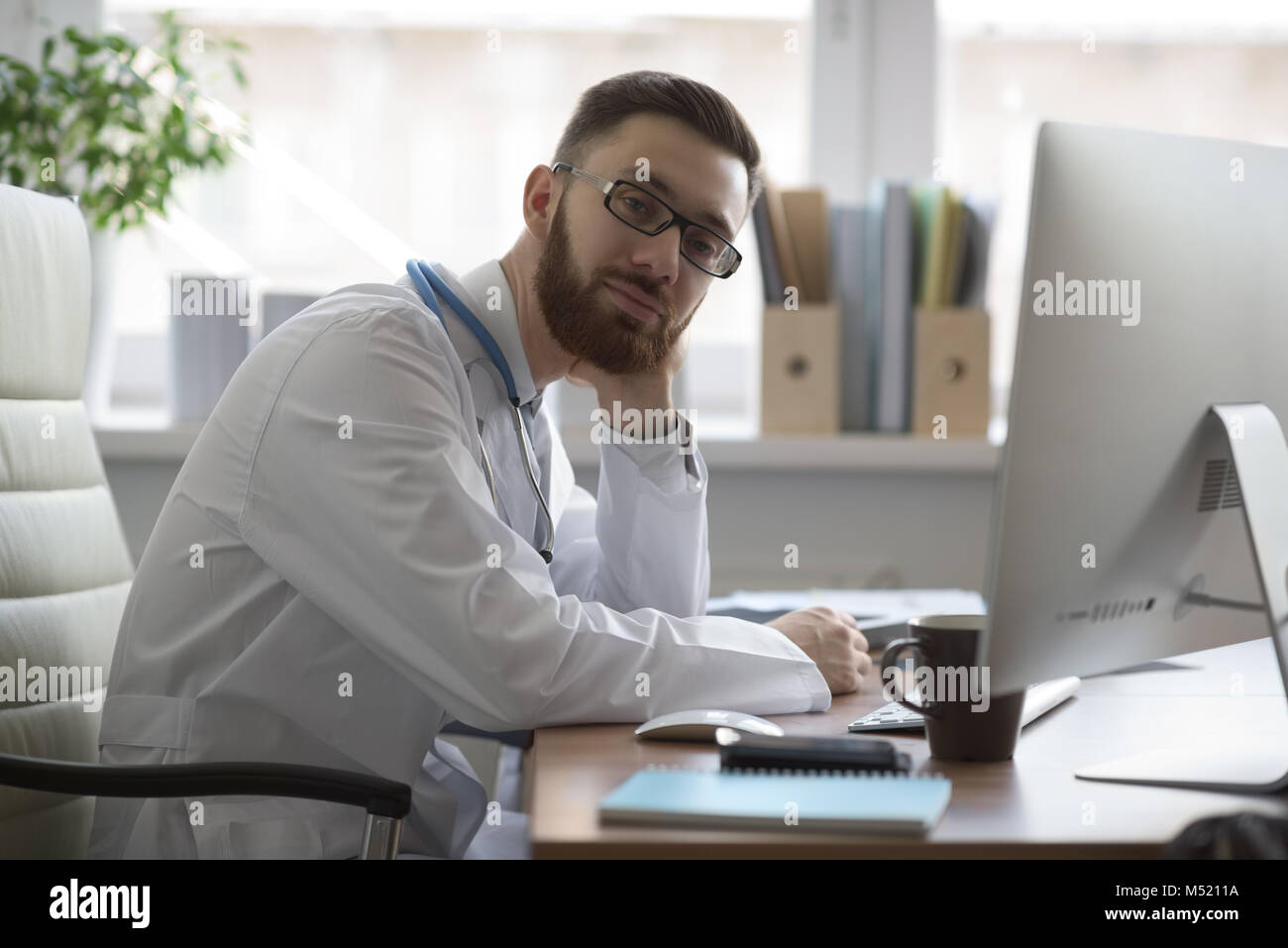 Doctor sitting relaxed in his chair in the office Stock Photo - Alamy