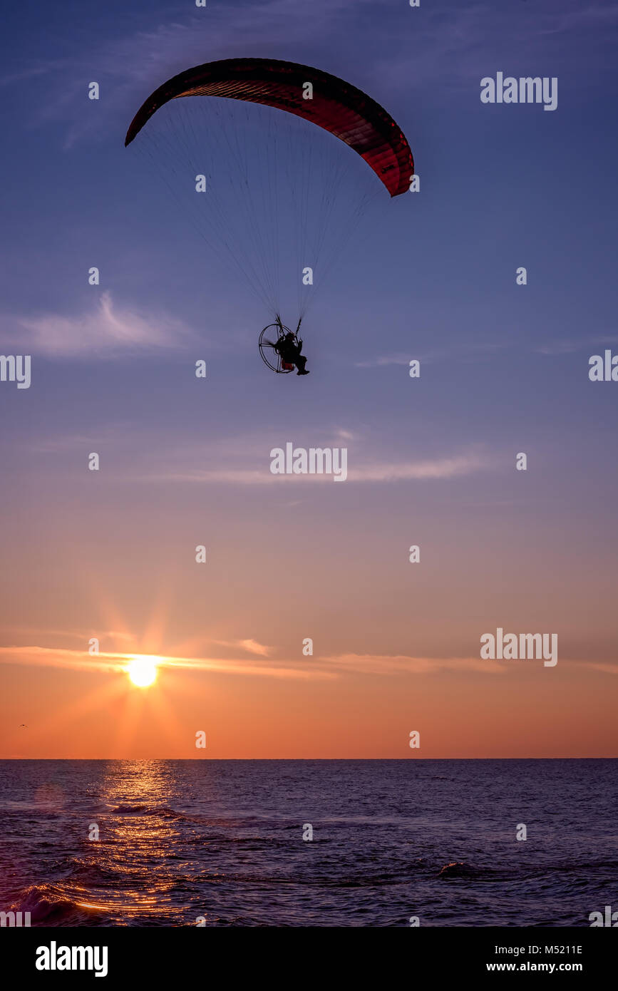 Paraglider flying at sunset Stock Photo - Alamy