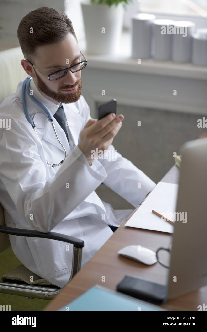 Doctor texting on his smartphone Stock Photo - Alamy