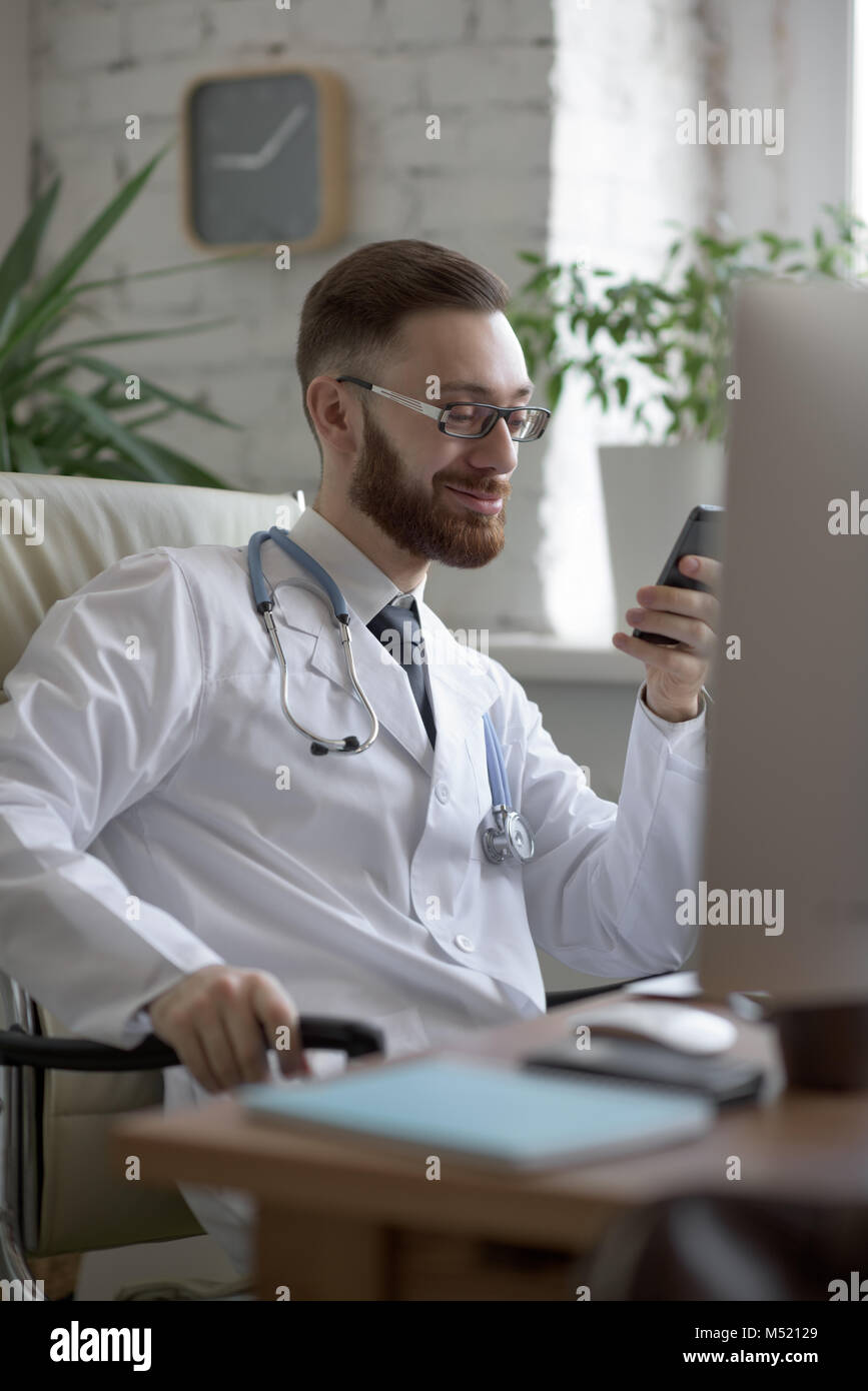 Doctor texting on his smartphone Stock Photo - Alamy