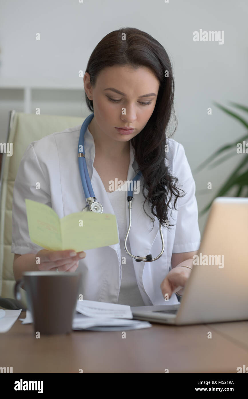 Doctor analyzing medical test results of her patient at her office ...