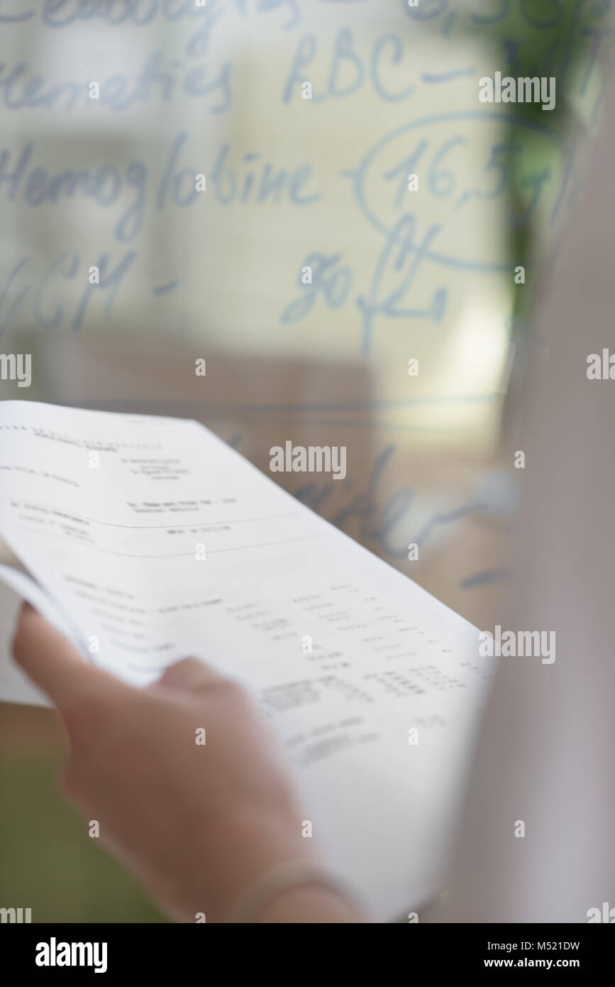 Medical doctor writing patient test results on transparent board to ...