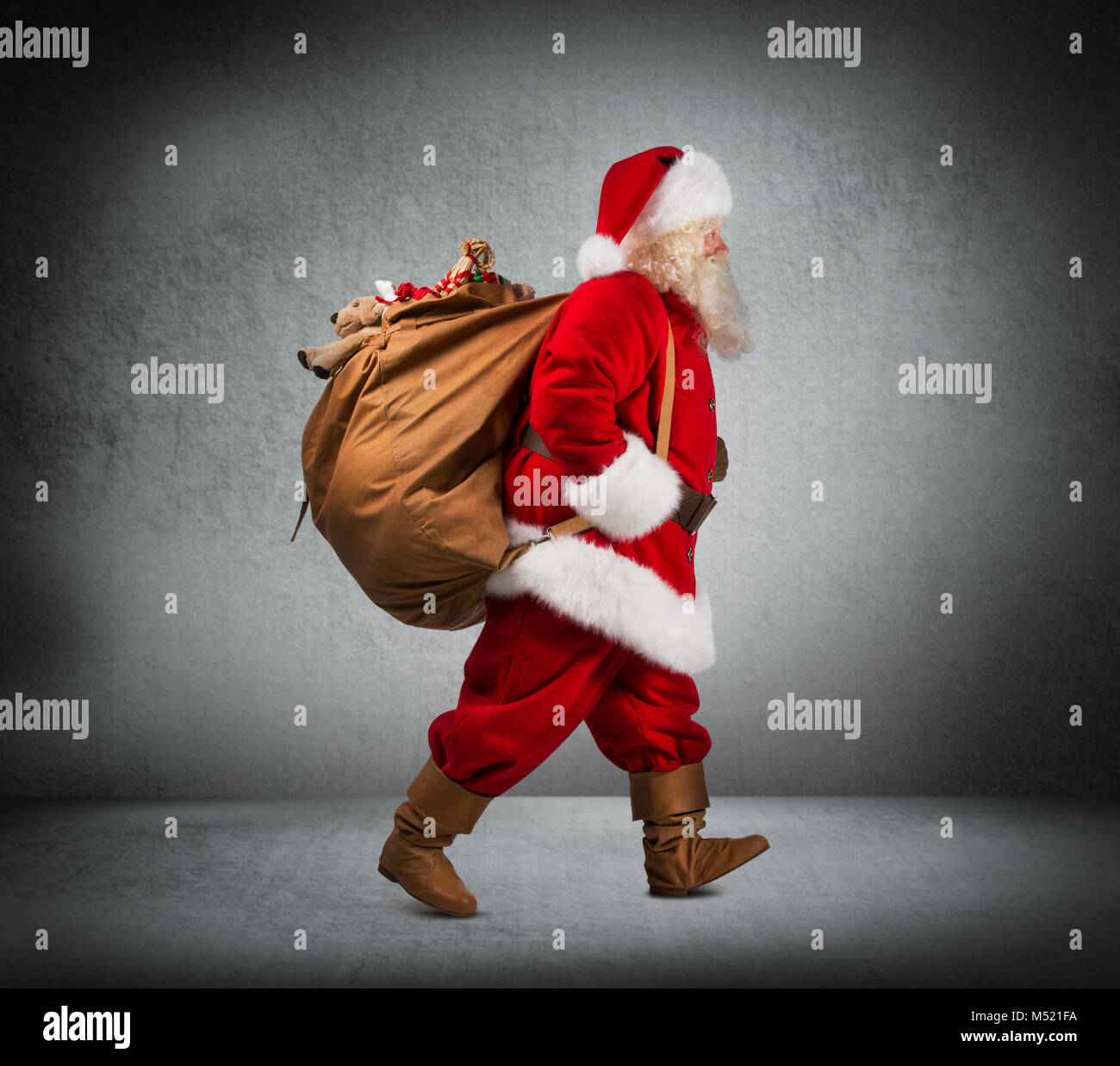 Santa Claus walking with the bag of the presents Stock Photo - Alamy