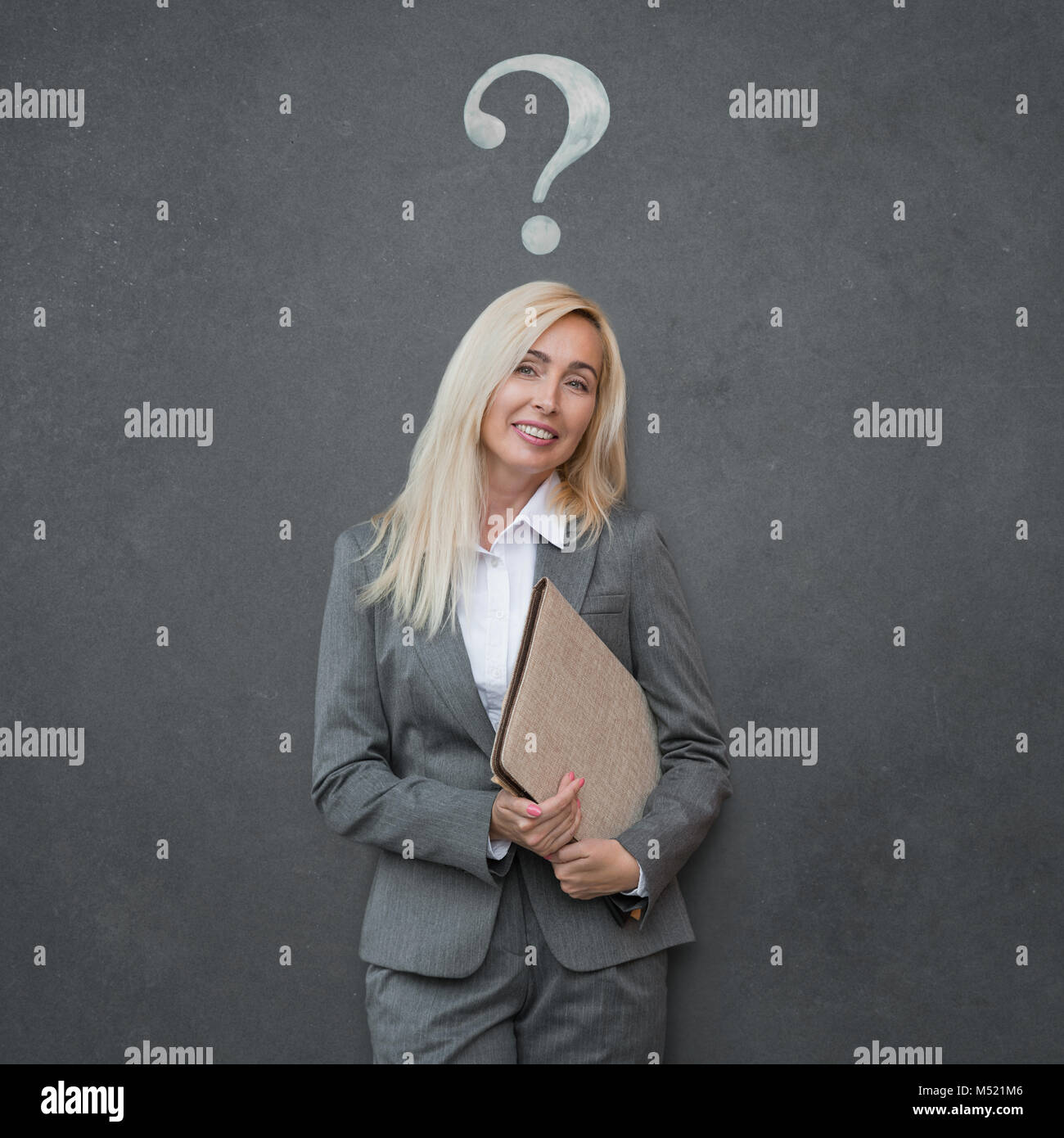 Thinking business woman looking up on question mark on gray background ...