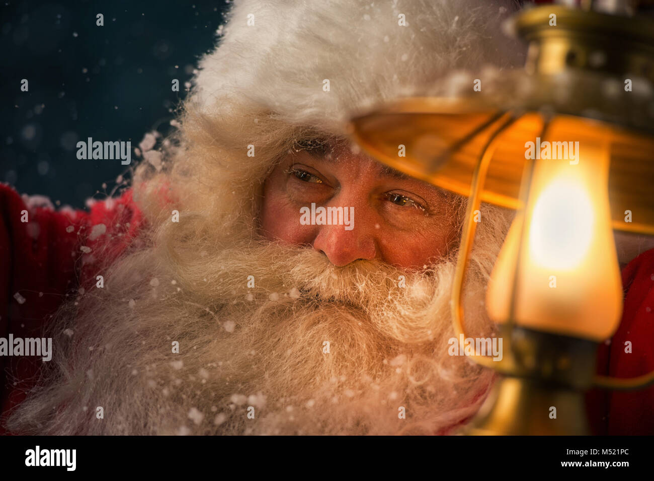 Santa Clause walking outdoors under falling snow with vintage lamp ...
