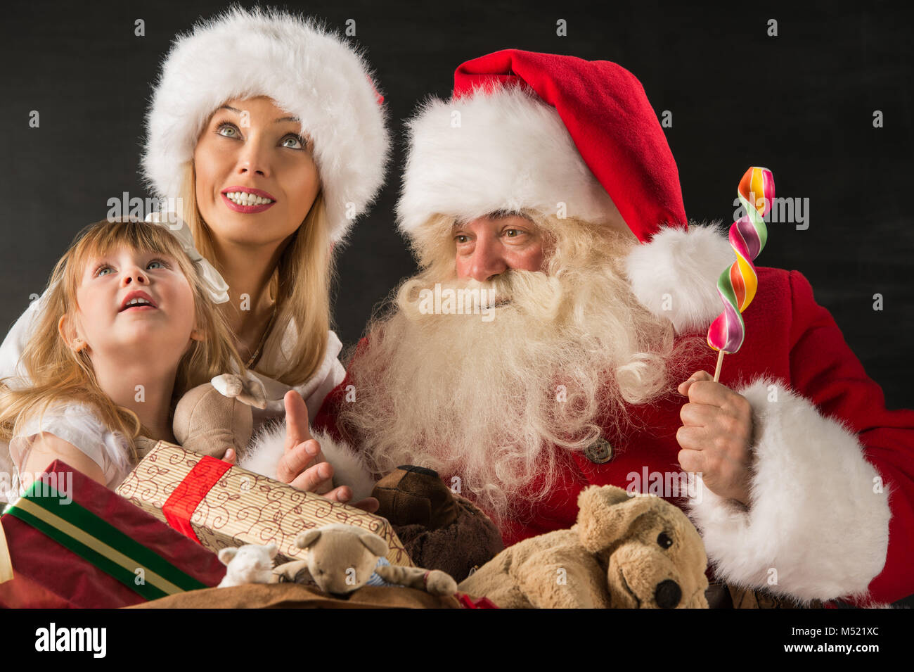 Santa Claus sitting at home with family - little girl and her mother ...