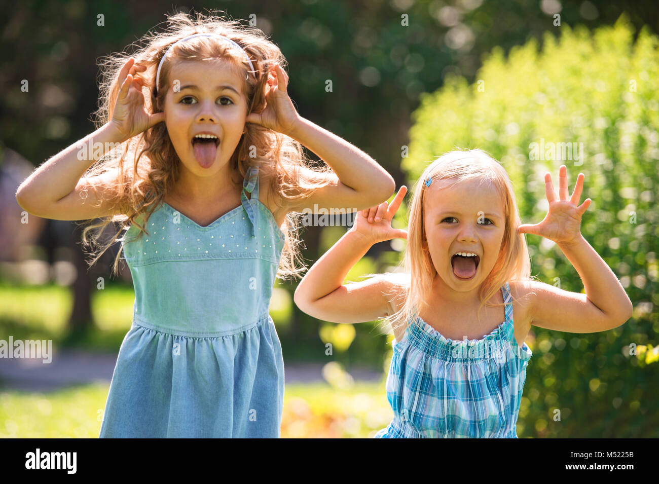 Happy childhood: Little girls having fun together outdoors in park ...