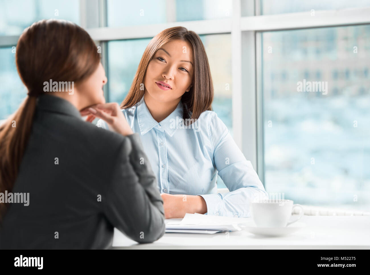 Two business women talking and signing contract at office Stock Photo ...
