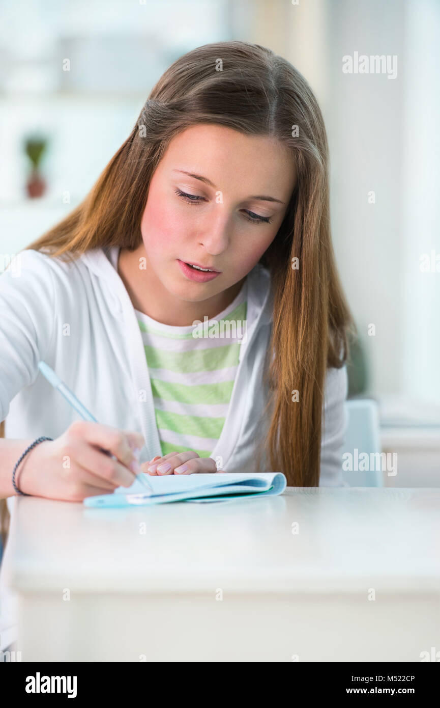High School students. Pretty female student making notes in classroom ...