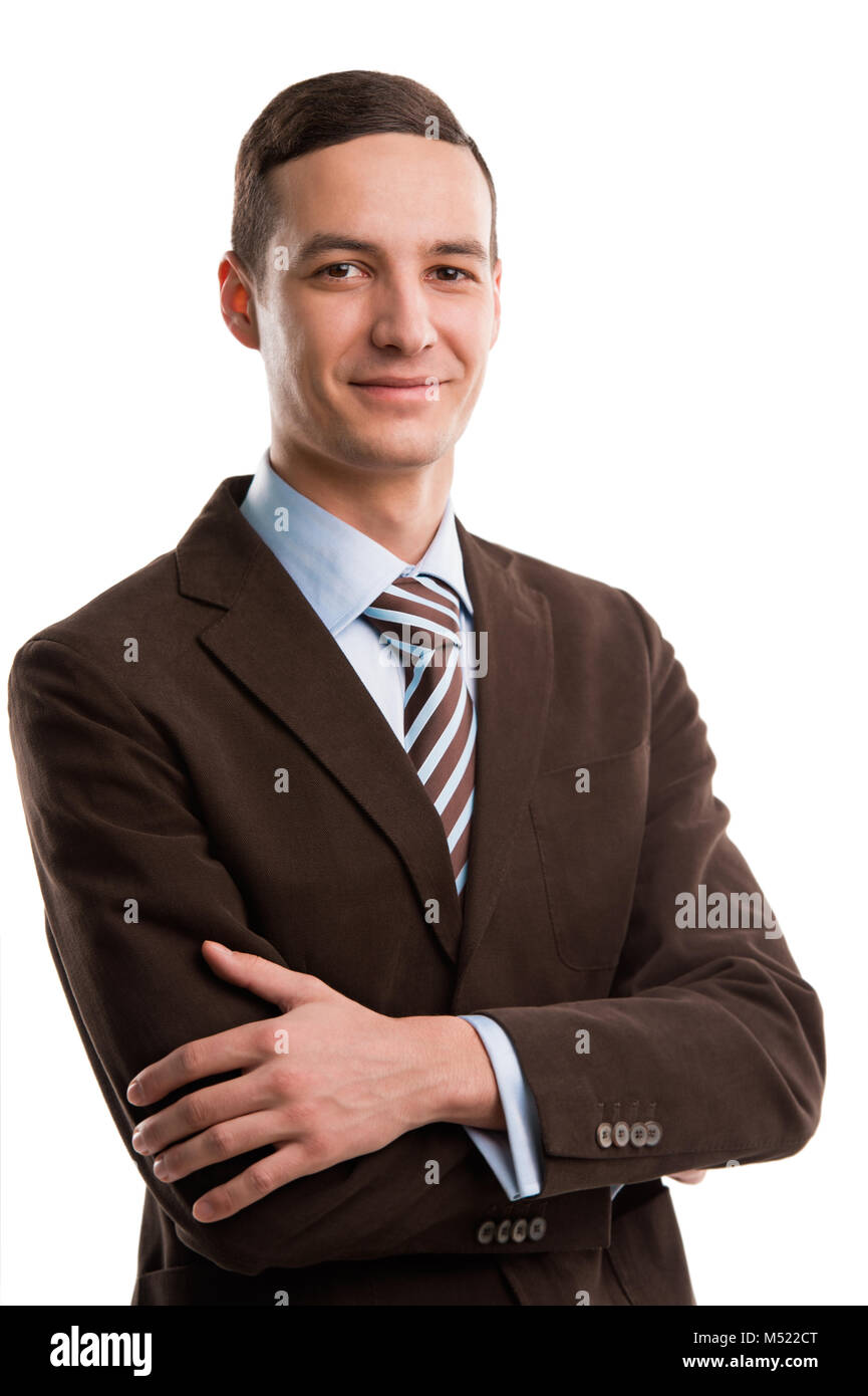 Portrait of handsome young business man standing with hands folded and ...