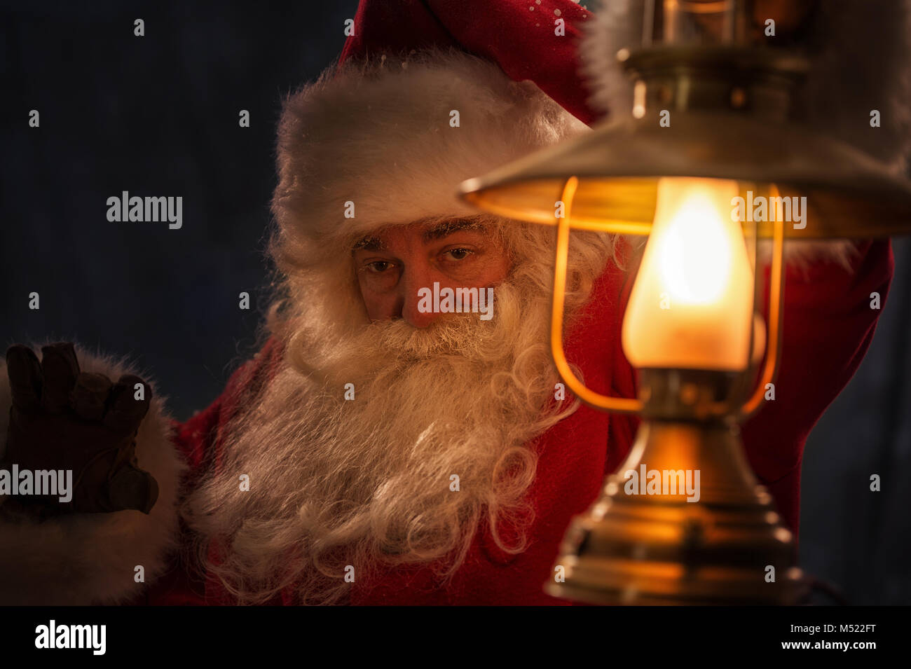 Santa Clause walking outdoors under falling snow with vintage lamp ...