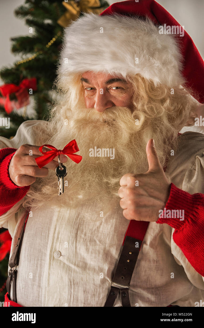 Santa Claus holding keys of new house or apartment and thumbs up ...