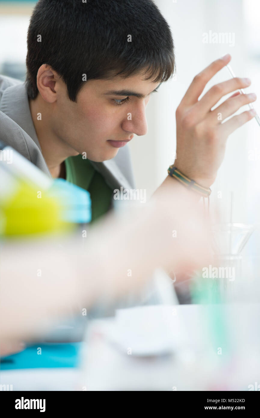 Male student with group of classmates on background working at the ...