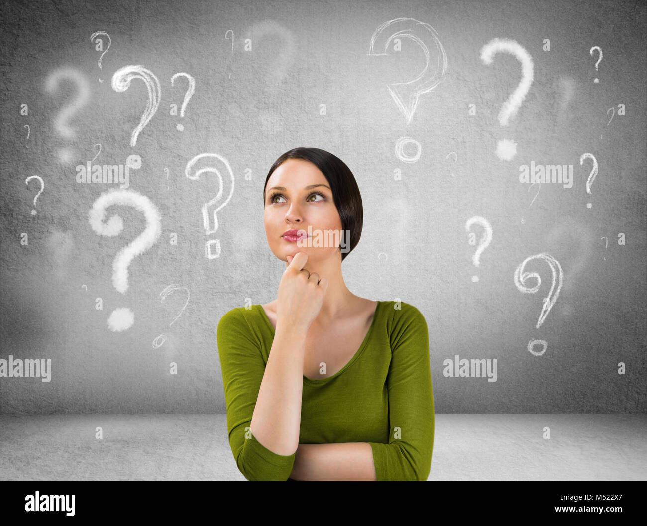 Beautiful woman with questioning expression and question marks above ...