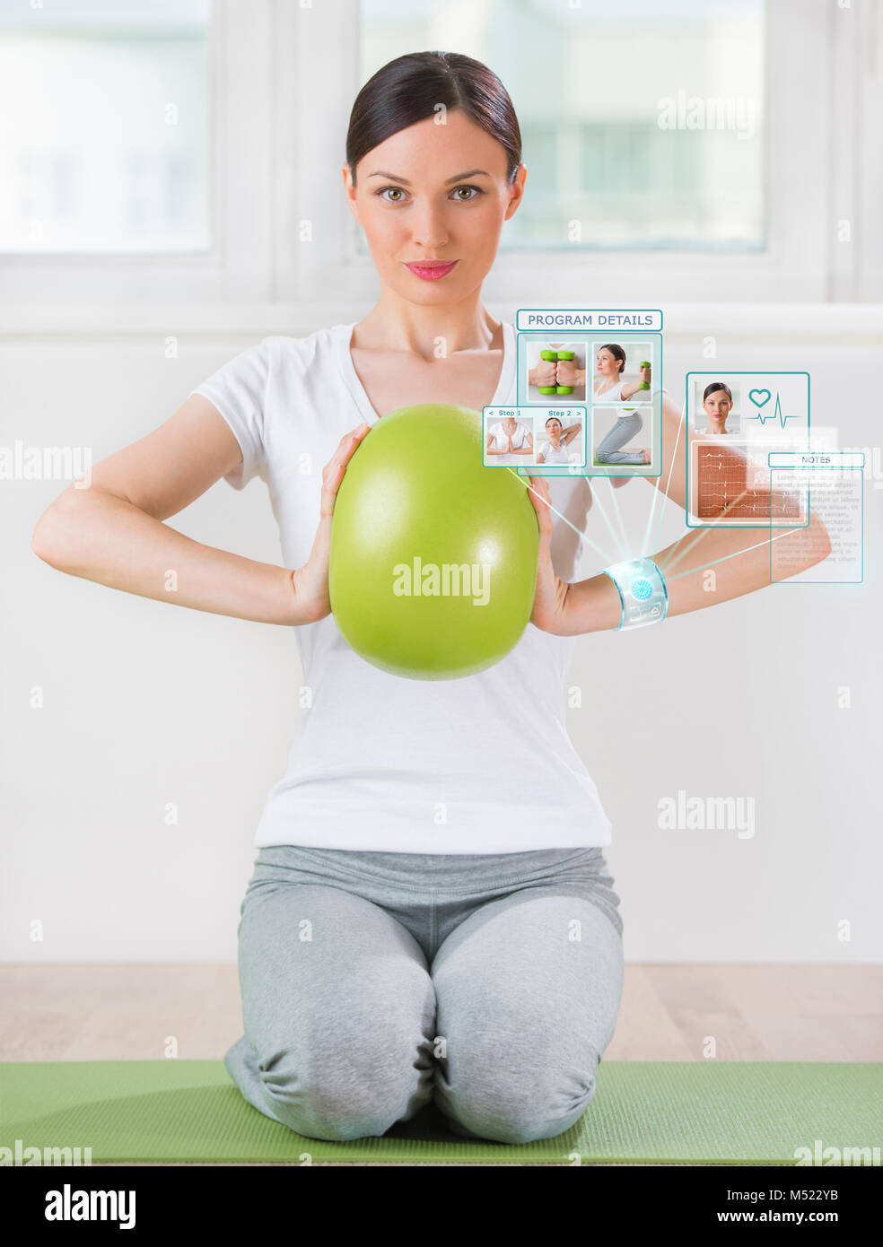 Woman doing exercise with ball wearing smart wearable device with ...