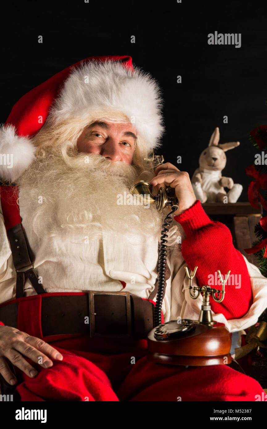 Santa Claus calling by vintage phone at home Stock Photo - Alamy