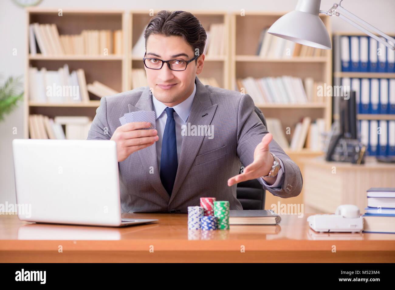 The businessman gambling playing cards at work Stock Photo - Alamy
