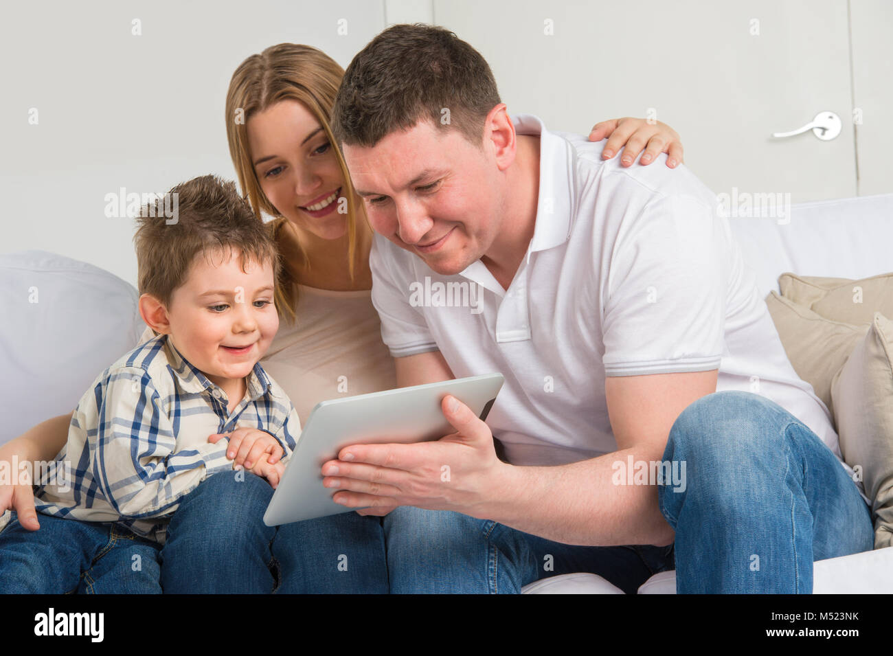 Happy family at home using electronic tablet to play together Stock ...