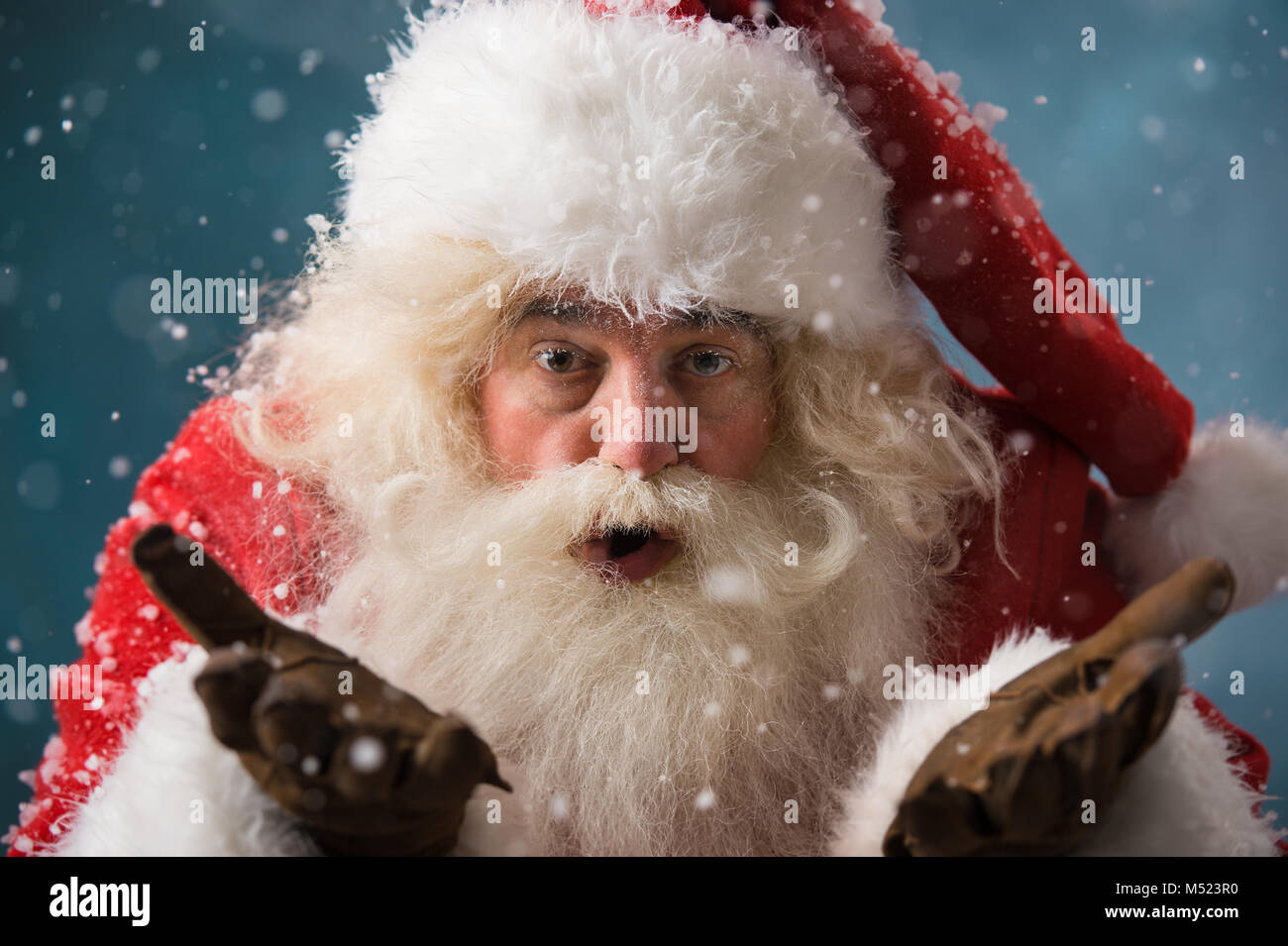 Santa Claus blowing snow and looking at camera outdoors in winter Stock ...