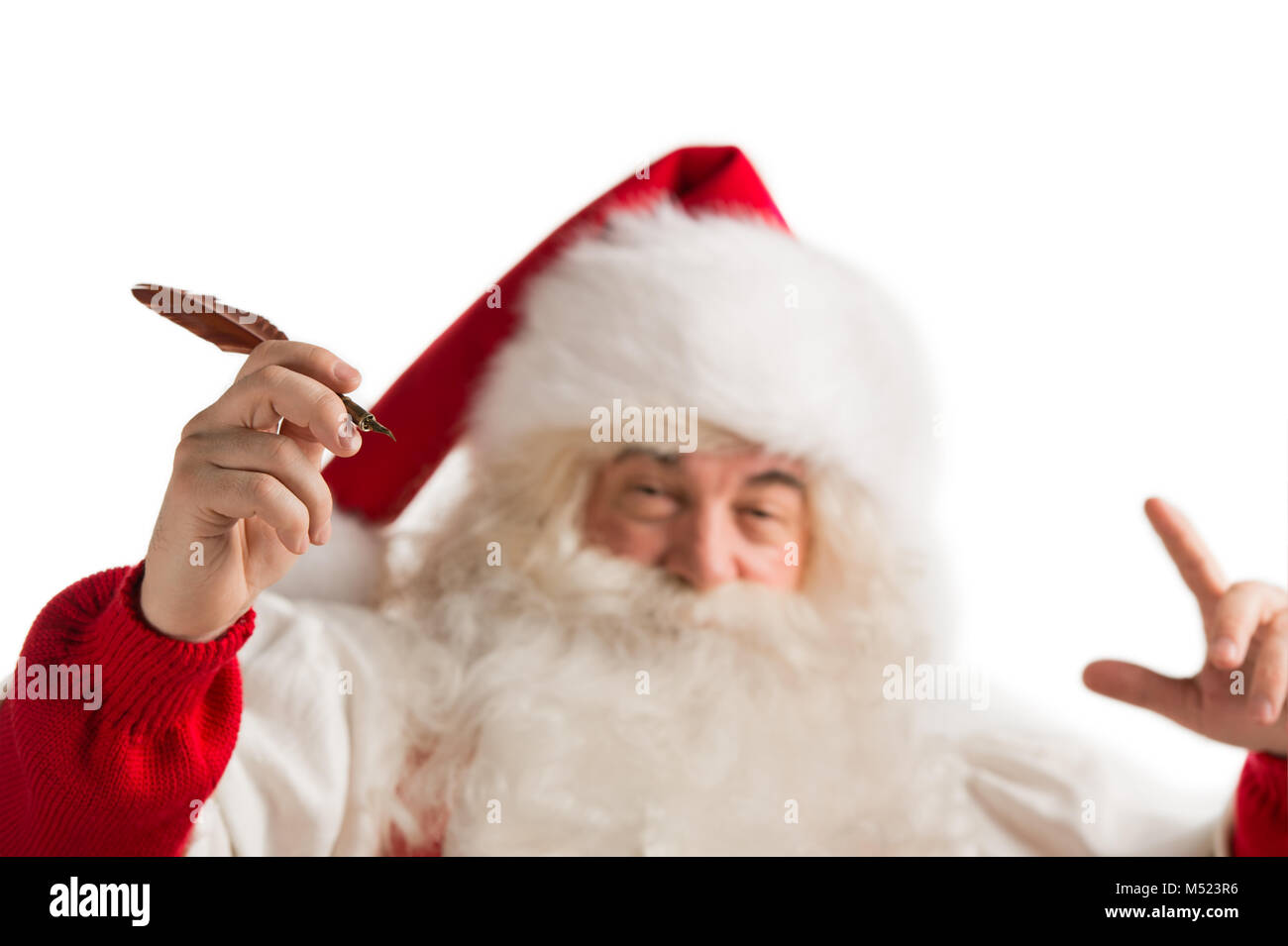 Santa Claus holding feather pen in his arm and writing Stock Photo - Alamy