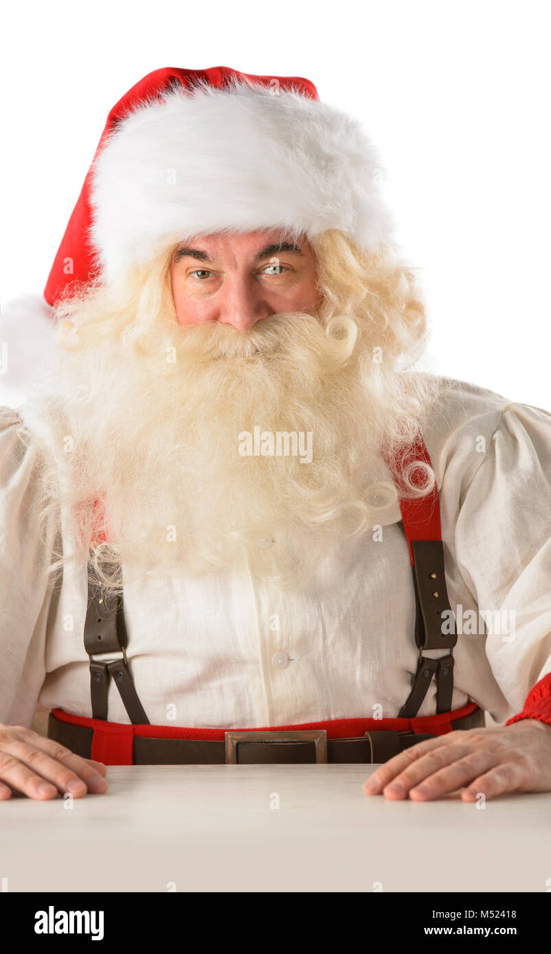 Santa Claus sitting at the table and looking at camera, isolated on ...