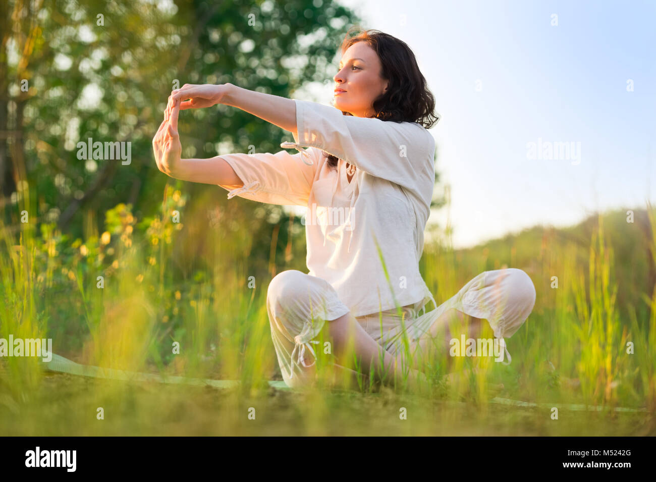 Stretching woman in outdoor exercise smiling happy doing yoga stretches ...