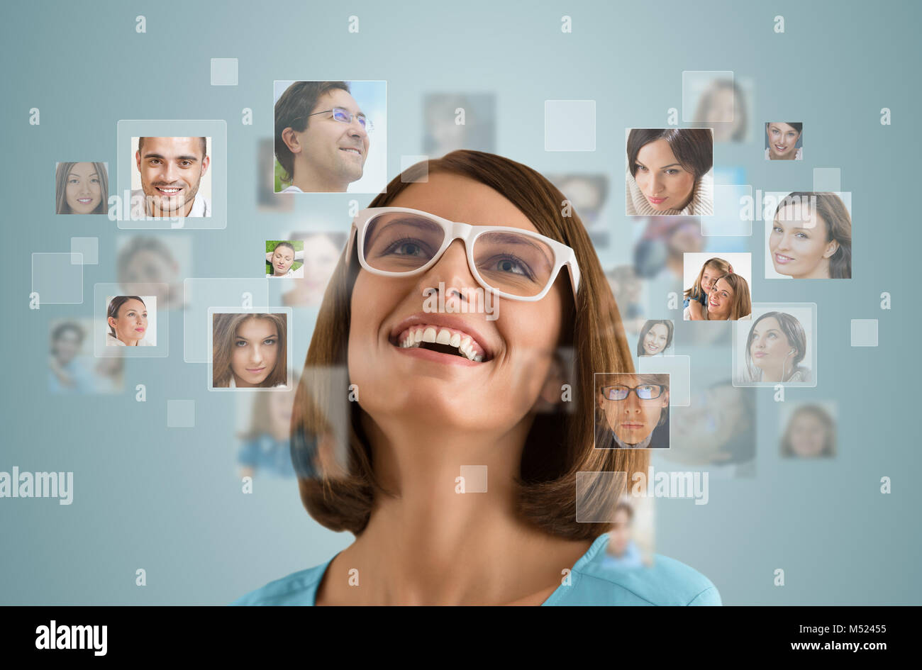 Young woman standing and smiling with many different people's faces ...