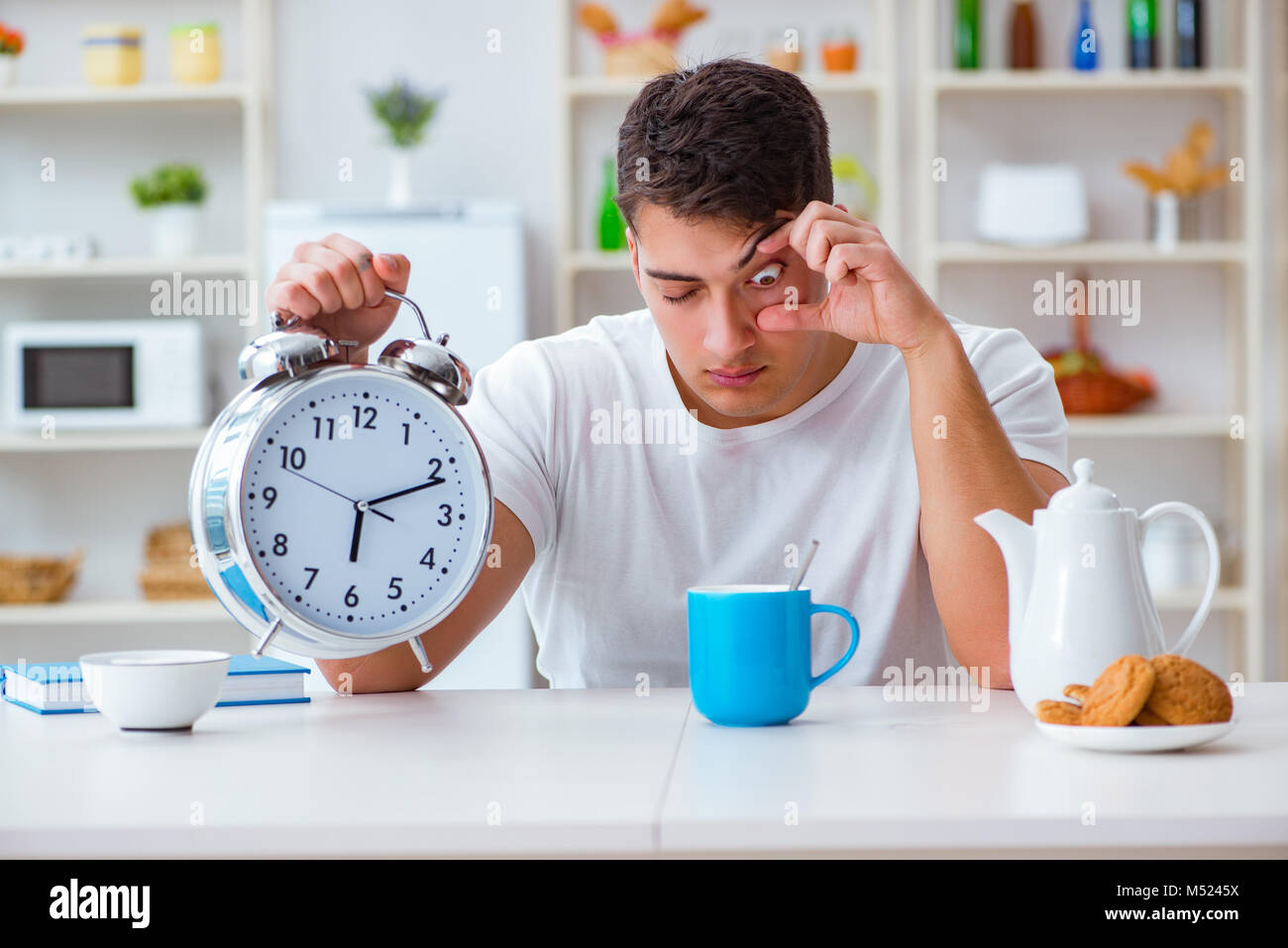 The man with alarm clock falling asleep at breakfast Stock Photo - Alamy