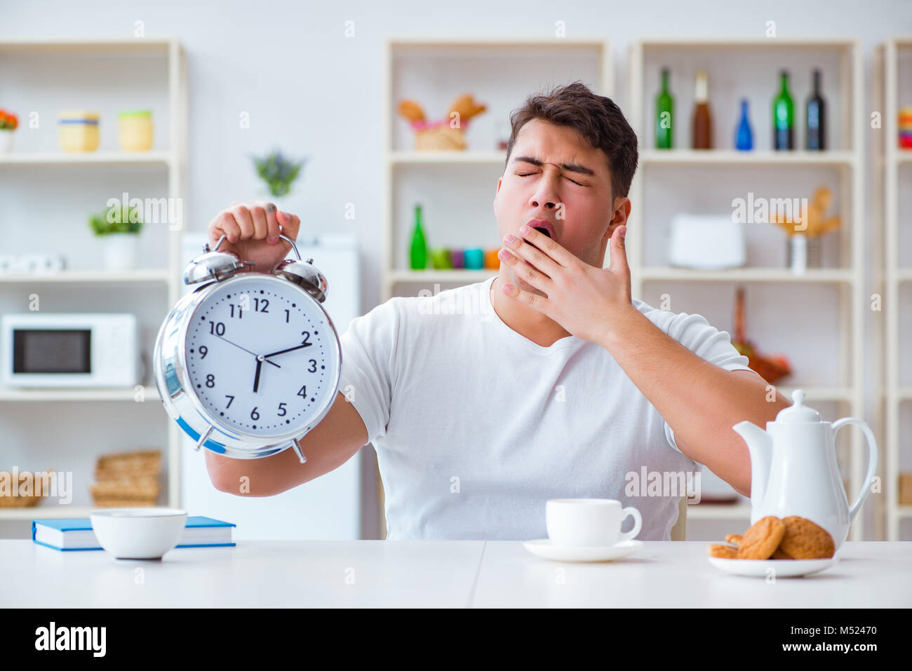 The man with alarm clock falling asleep at breakfast Stock Photo - Alamy