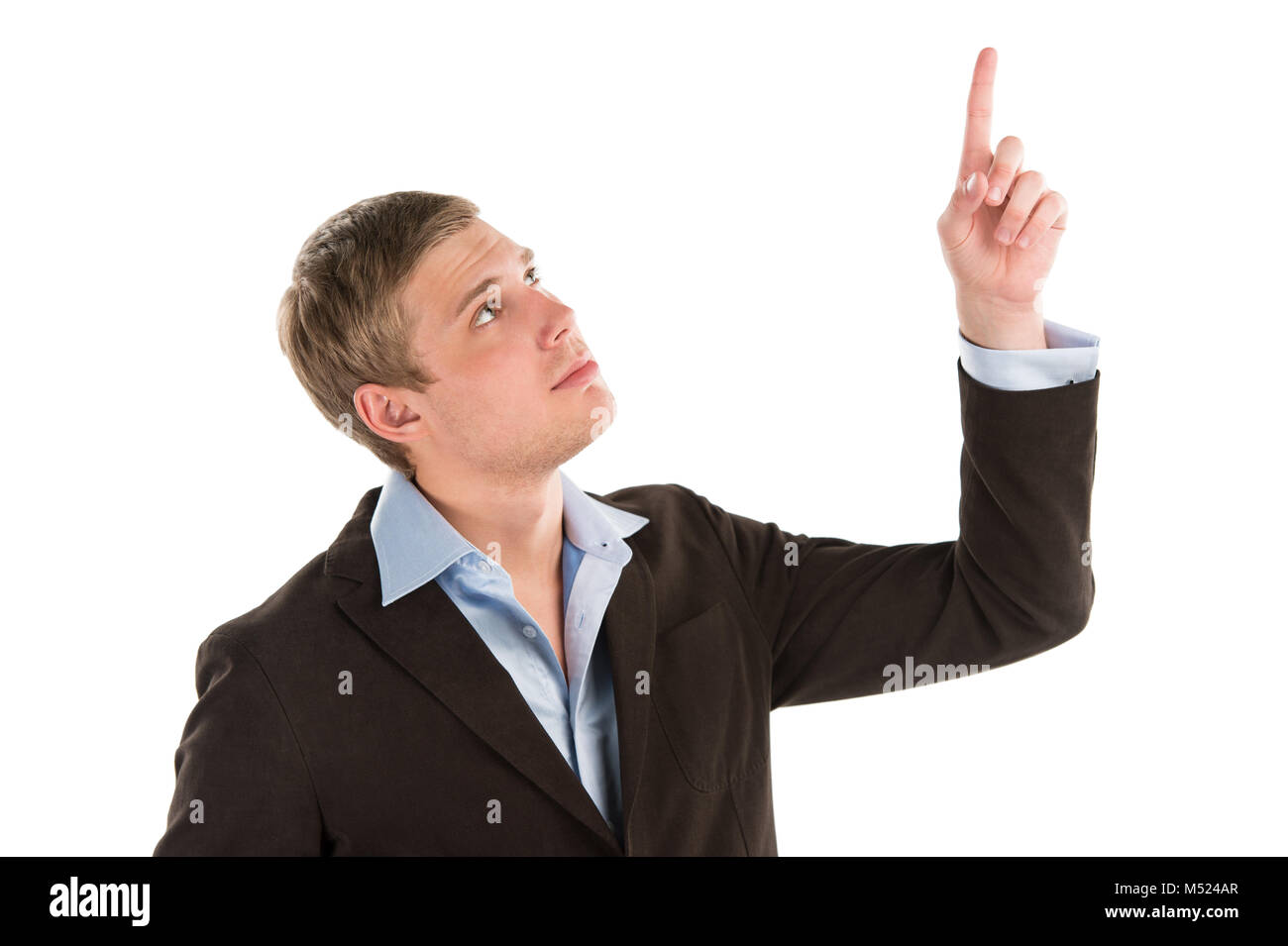 A confident young businessman pointing upwards while isolated on a ...