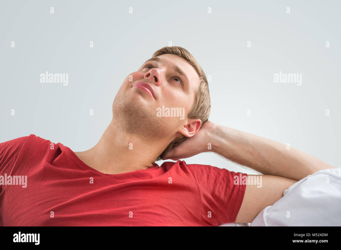 Portrait of a handsome young man looking upwards while relaxing and ...