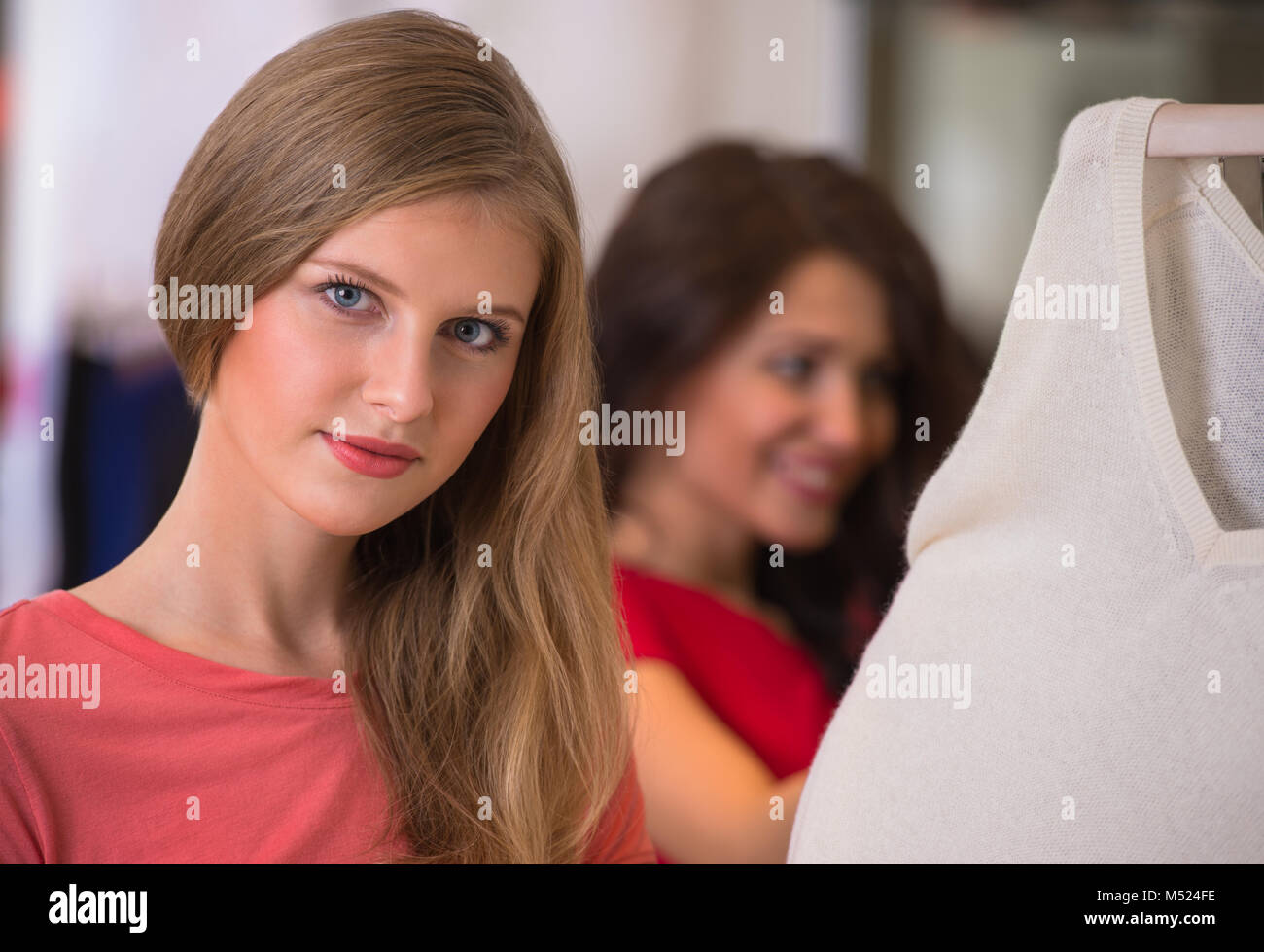Woman shopping clothes. Shopper looking at camera indoors in store ...