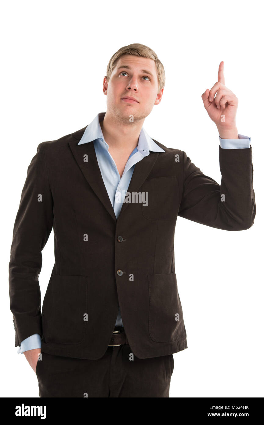 A confident young businessman pointing upwards while isolated on a ...