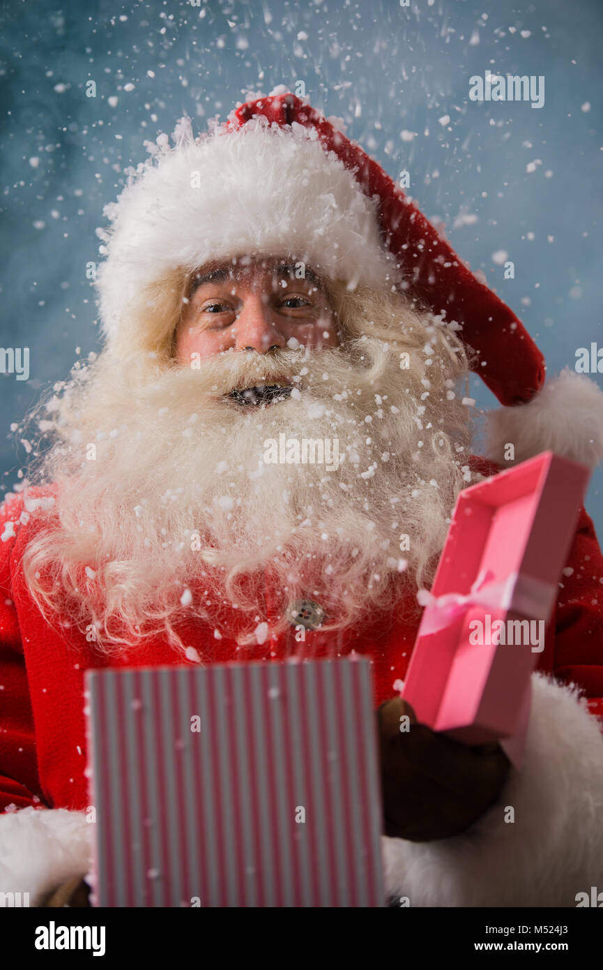 Happy Santa Claus opening his Christmas gift at North Pole Stock Photo ...