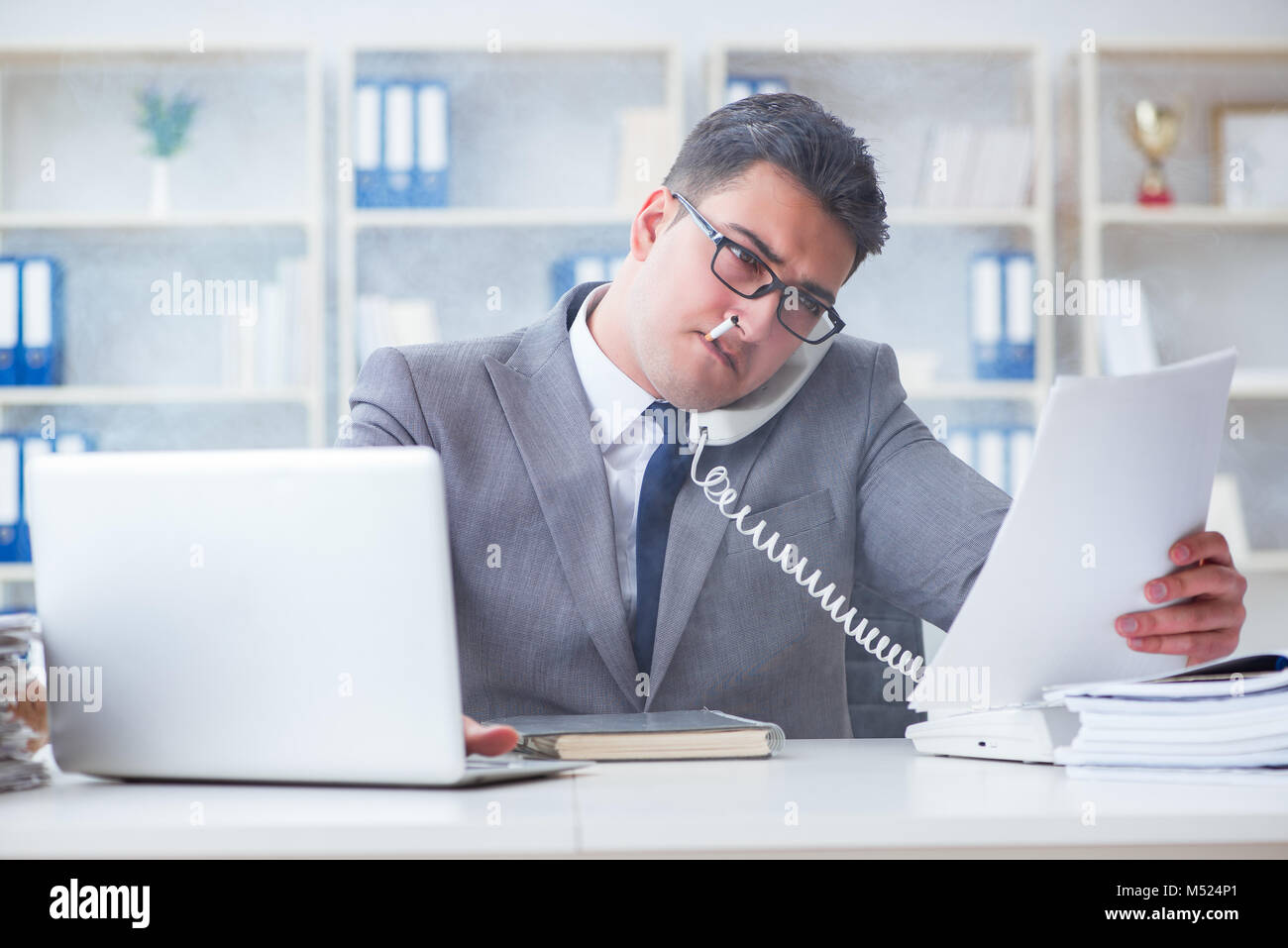 The businessman smoking in office at work Stock Photo - Alamy