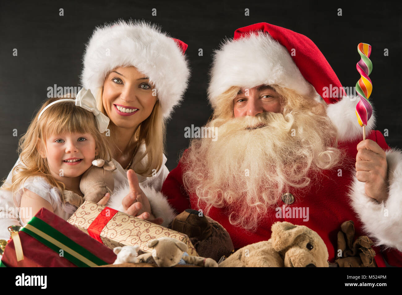 Santa Claus sitting at home with family - little girl and her mother ...