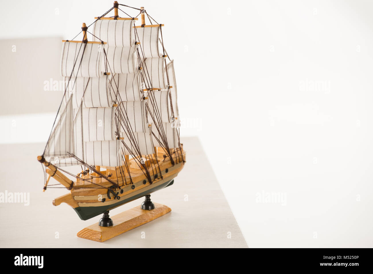 Wooden ship toy model on white table against white background Stock ...