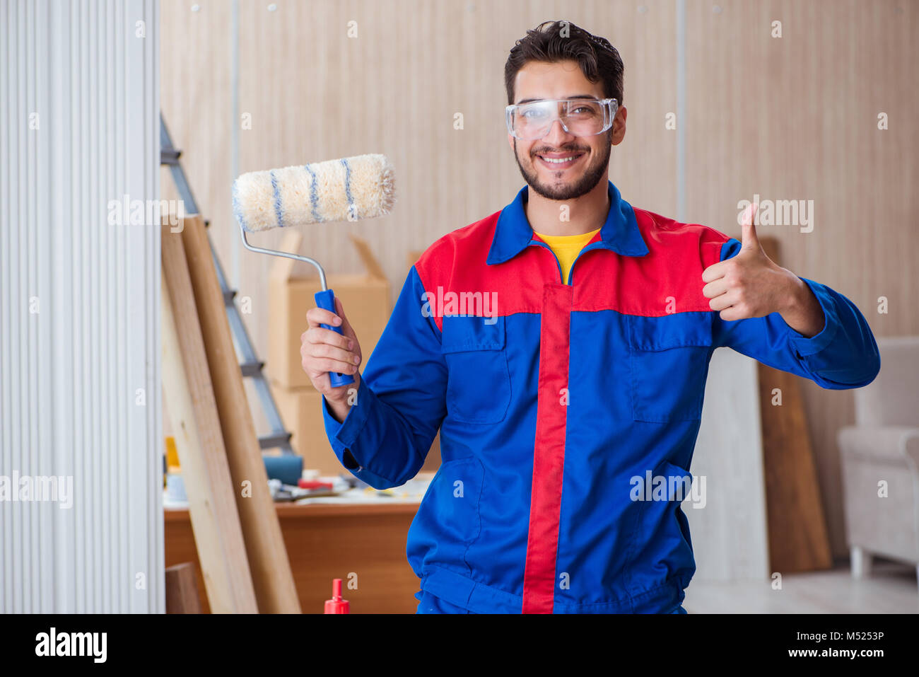 The yooung repairman carpenter working with paint painting Stock Photo ...