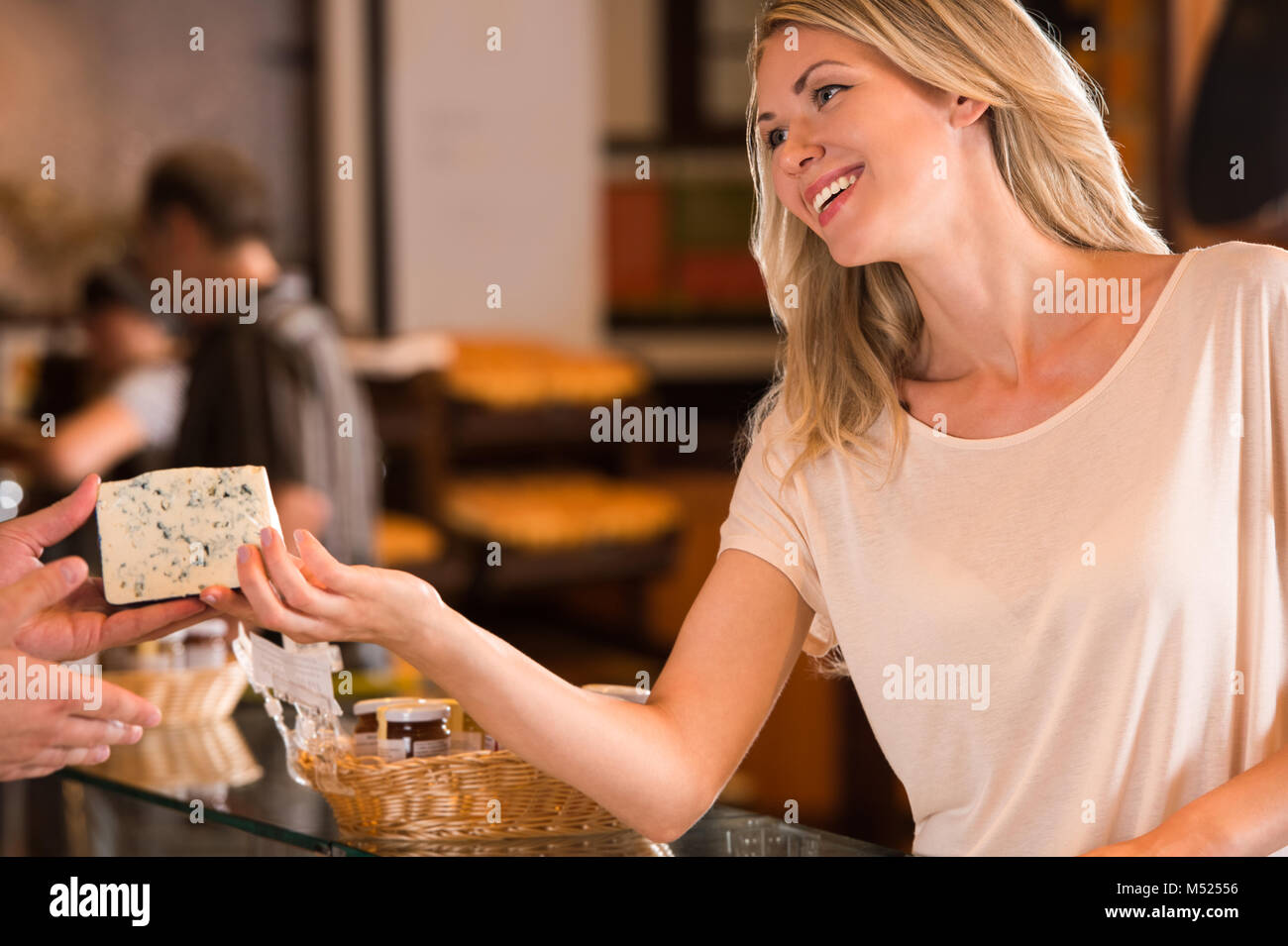 Woman buying cheese at grocery store Stock Photo - Alamy
