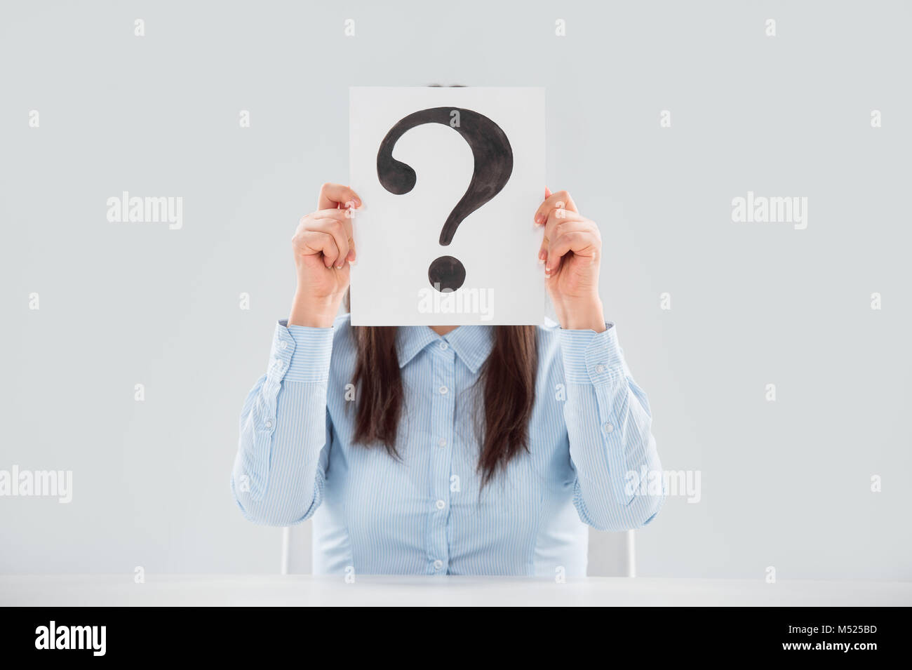 Business woman holding question mark signboard paper in front of face ...