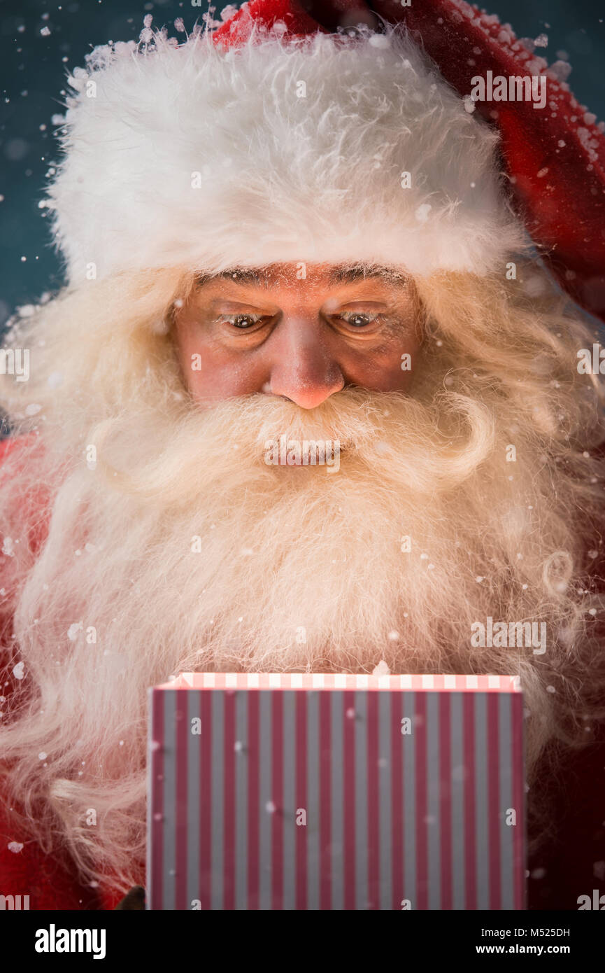 Happy Santa Claus opening his Christmas gift at North Pole Stock Photo ...
