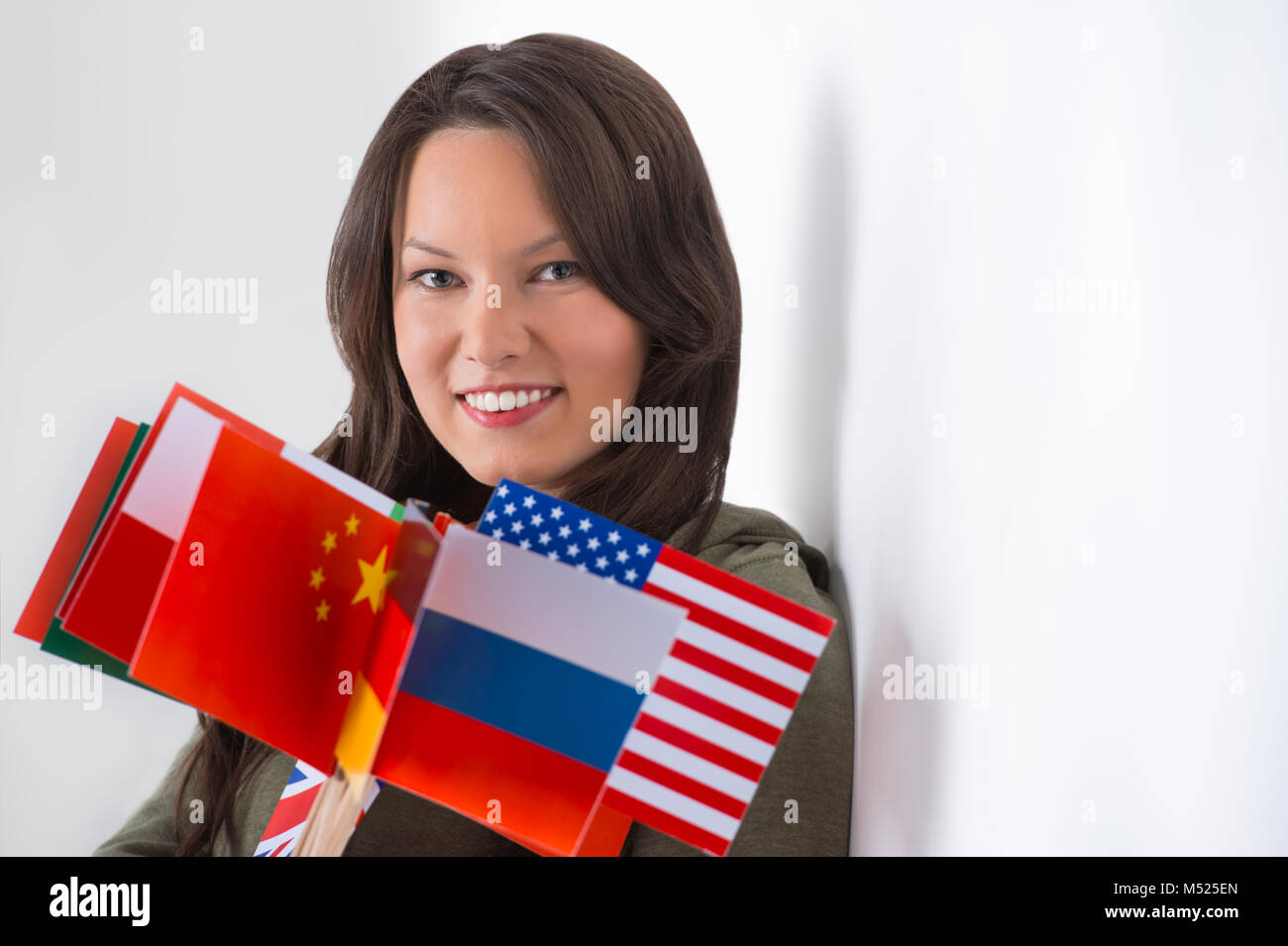 Portrait of a lovely young woman with different countries flags smiling ...