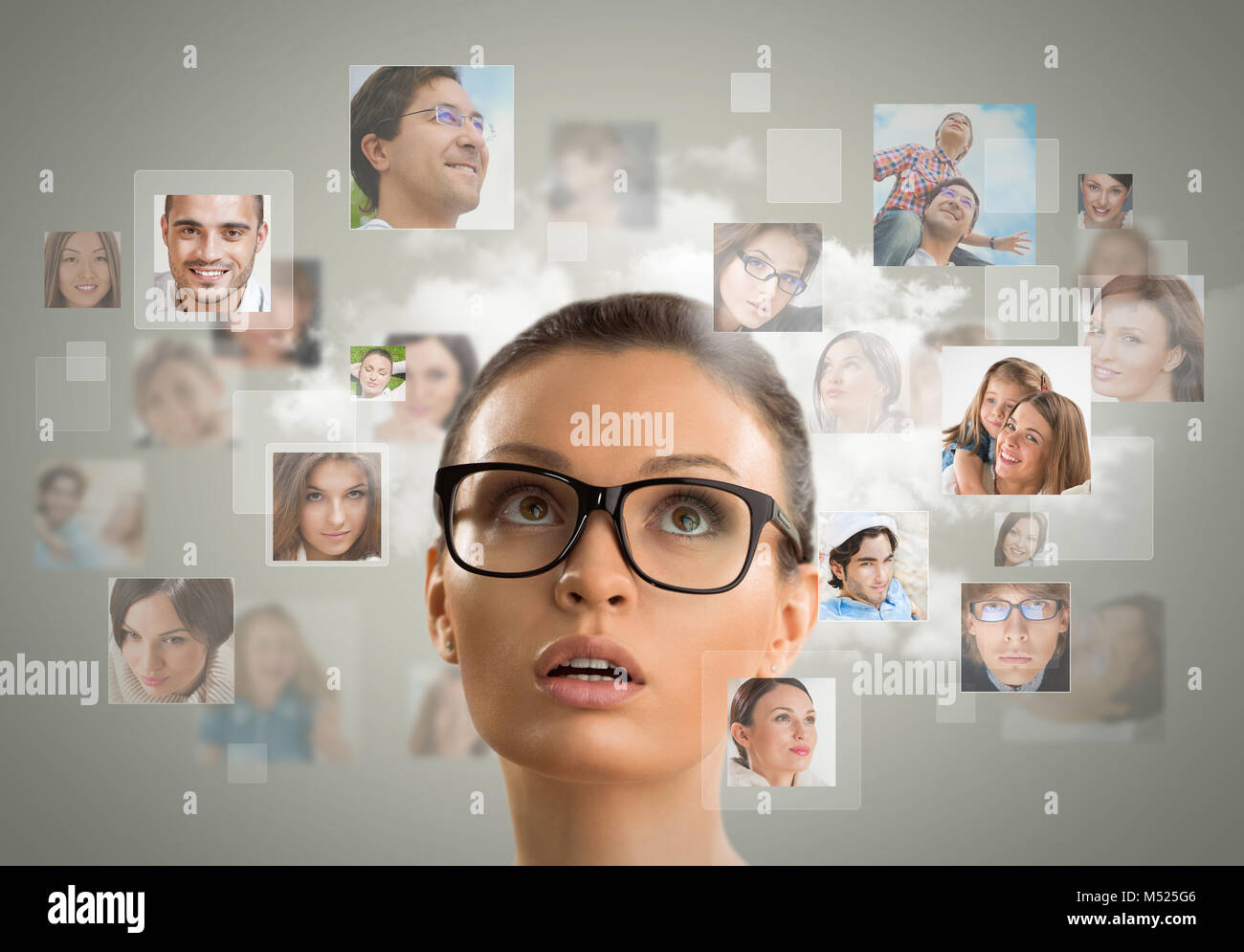 Young woman standing and smiling with many different people's faces ...