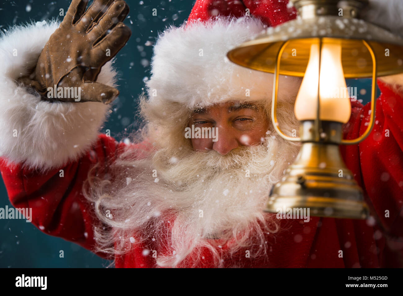 Santa Claus is holding a shining lantern while sneaking to his home ...