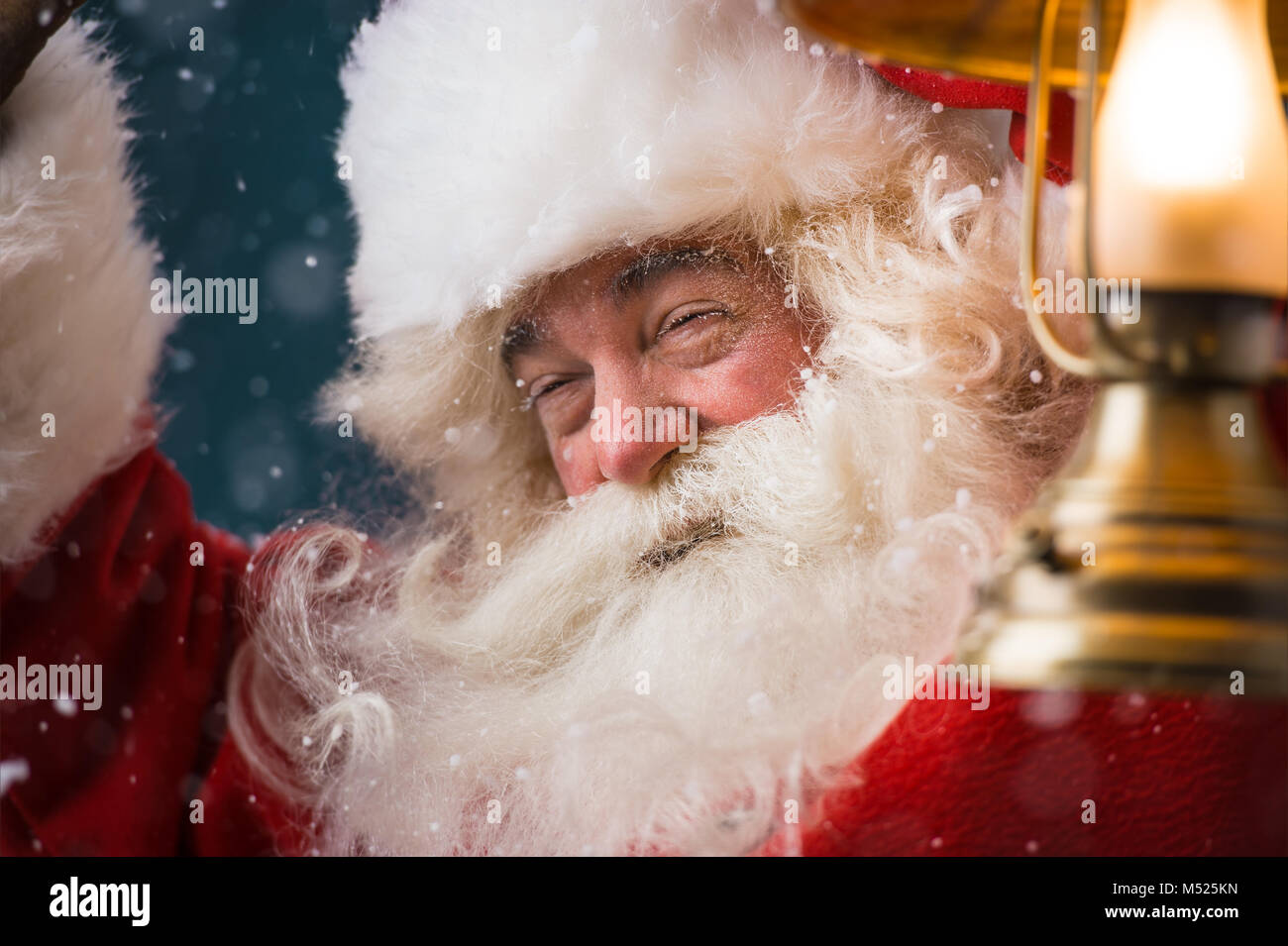 Santa Claus is holding a shining lantern while sneaking to his home ...