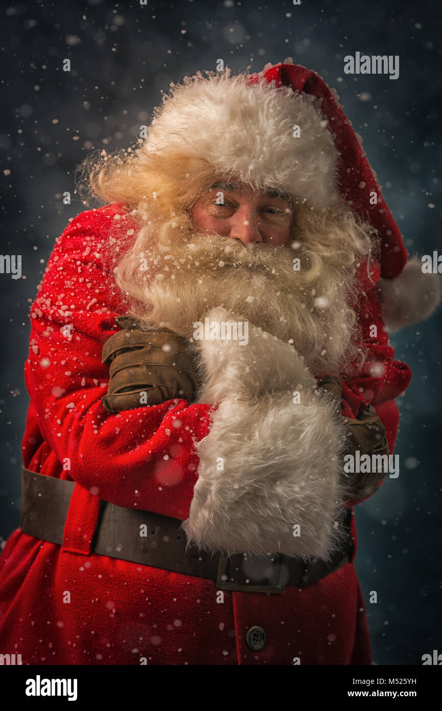 Santa Claus is feeling very cold standing outdoors at snowfall at north ...