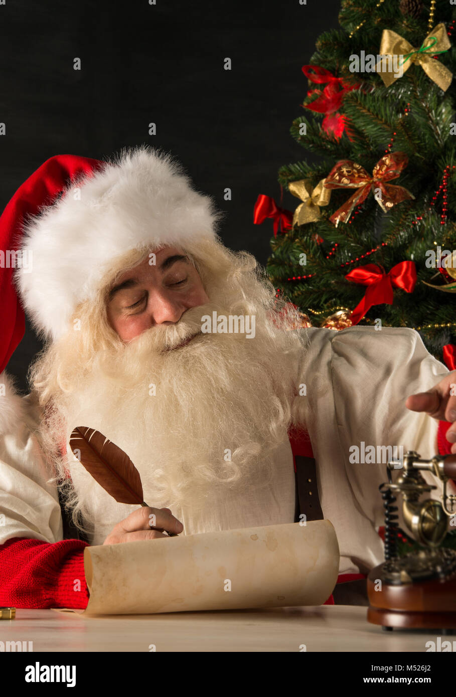 Portrait of Santa Claus answering Christmas letters using vintage tools ...