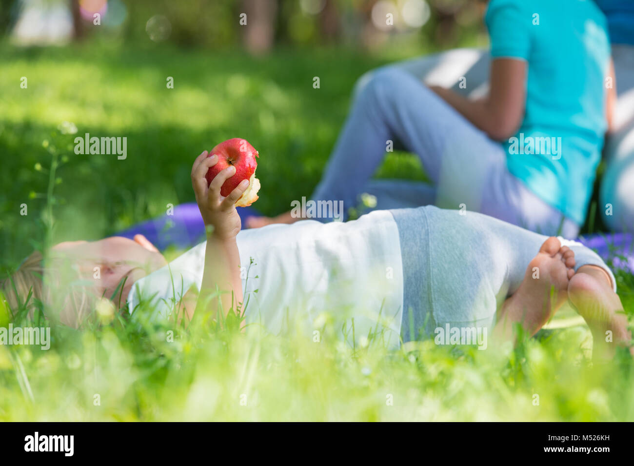 Group of happy children having fun on green grass outdoors in spring ...