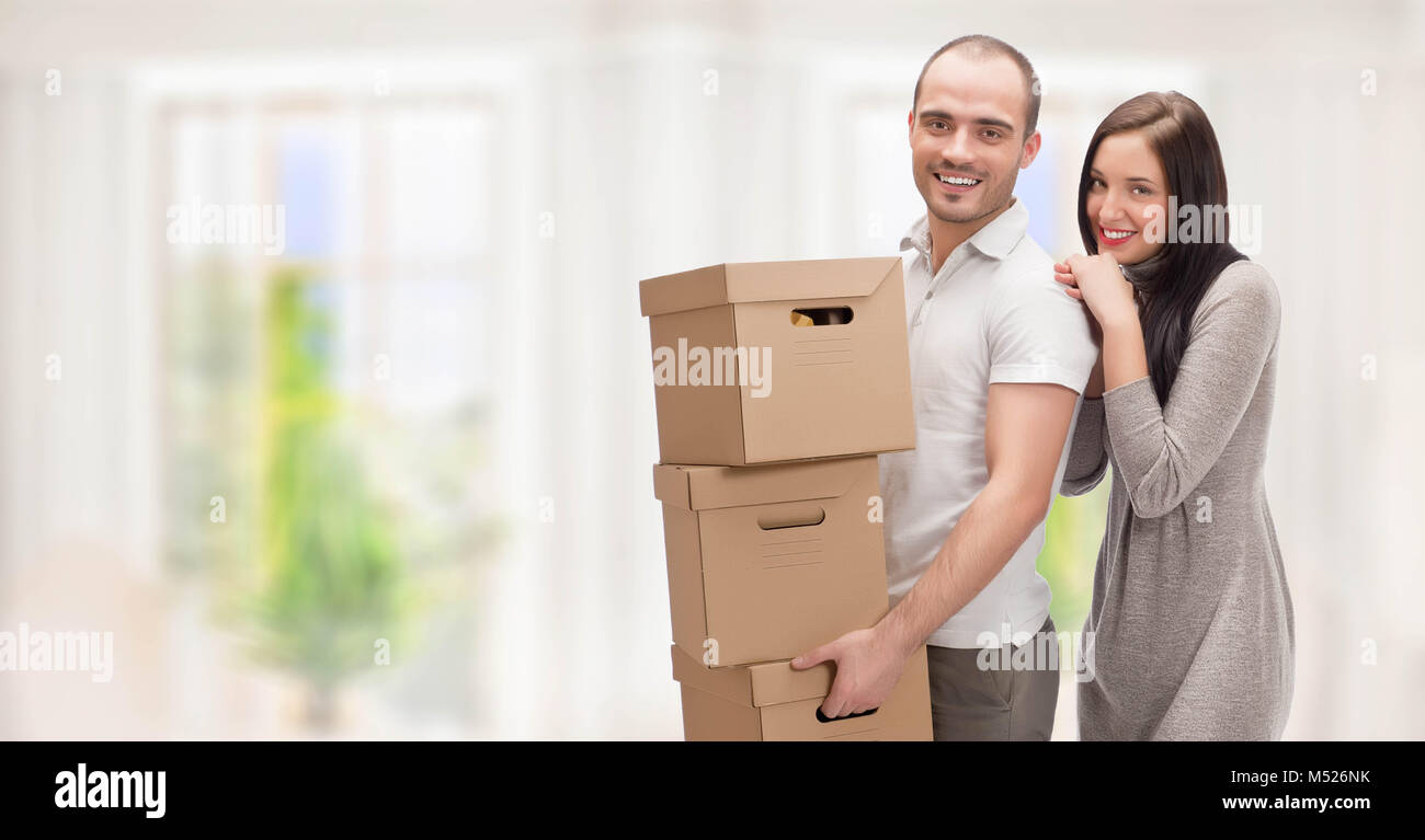 Young couple carrying cardboard boxes for their new home Stock Photo ...